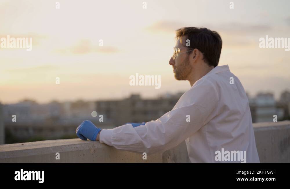Scientist looking at the horizon over a lab building during sunset or ...