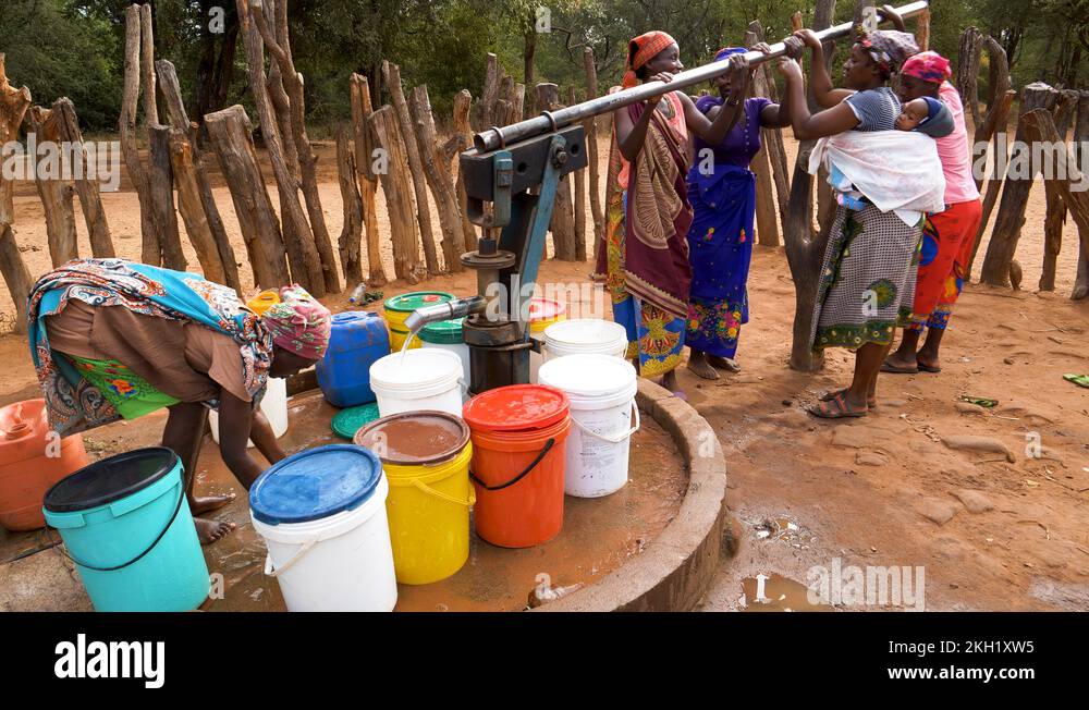 Water crisis. Close-up view of five woman, a baby drawing water into ...