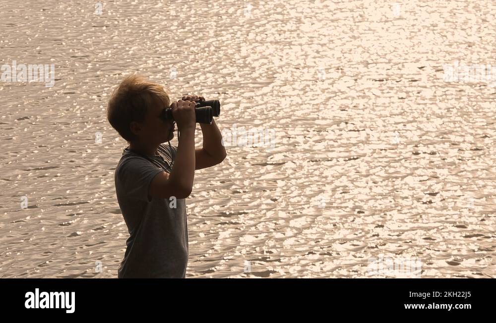 Black silhouette of kid exploring nature using old vintage binoculars ...