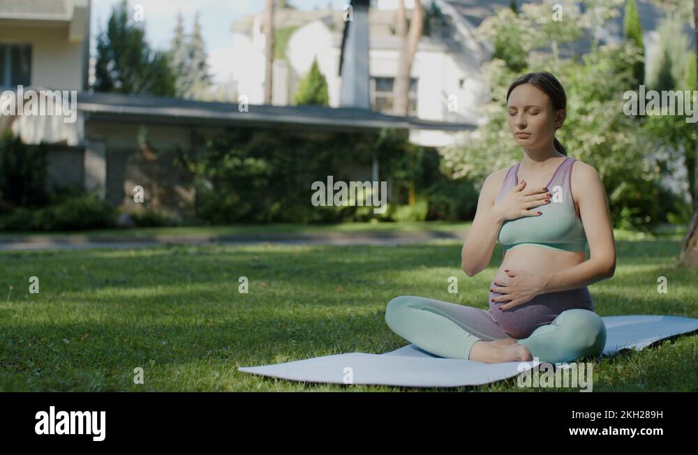 Pregnant woman doing yoga practice breathing exercises with hand on belly Stock Video Footage ...