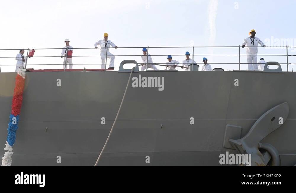 Sailors lowering anchor rope from USS Fort McHenry at Naval Station ...