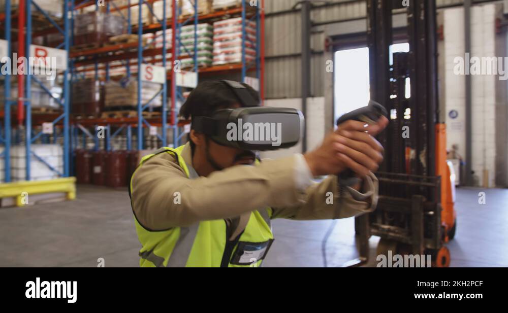 Male warehouse worker using VR headset and controller in loading bay 4k ...