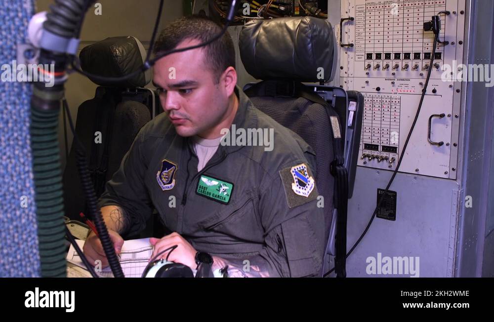 U.S. Air Force flight engineer recording flight data aboard E-3 Sentry ...