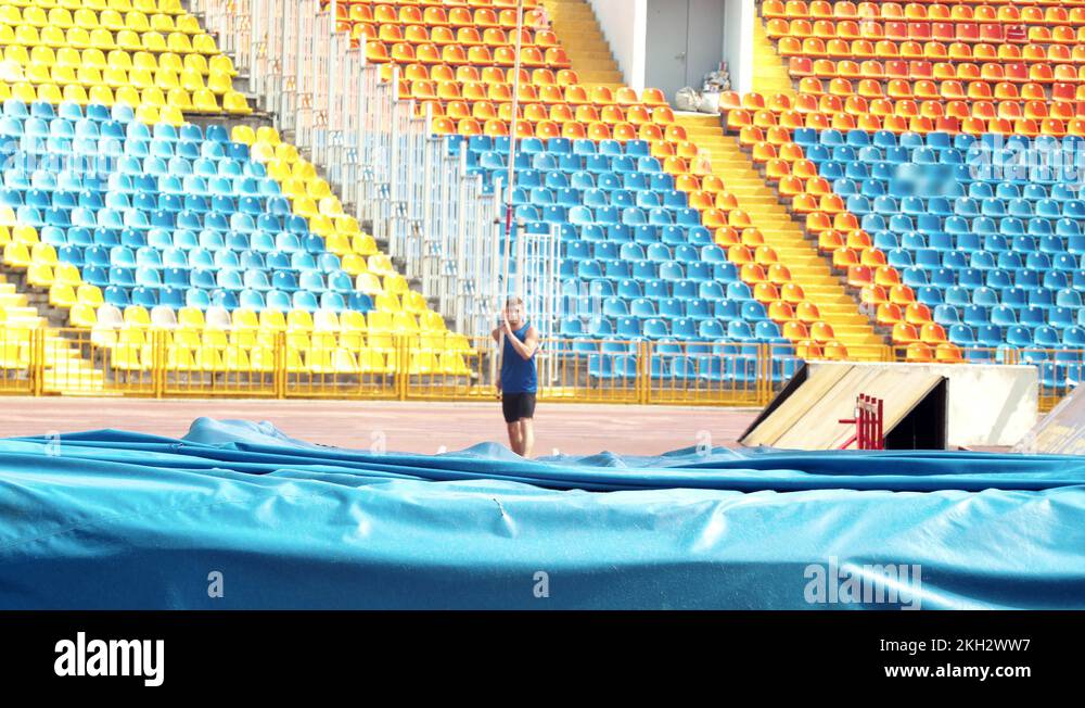 Pole vault - a young man running up holding a pole - indoors Stock ...