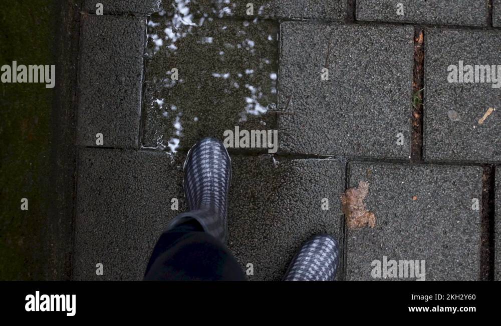 Rubber Boots Stepping into Puddle of Water on Tiled Road Stock Video ...