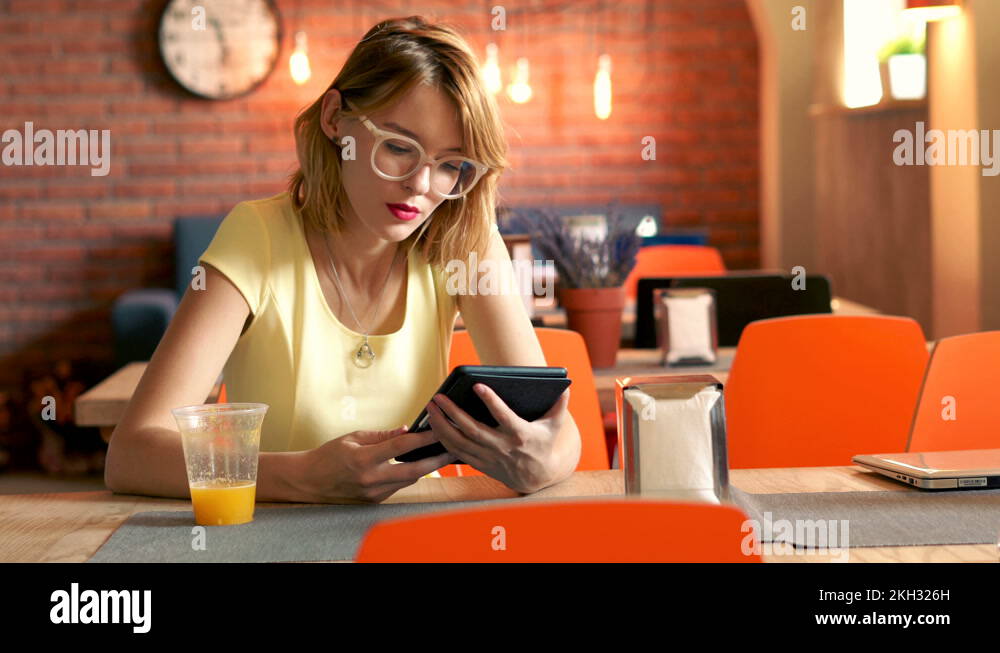 Pretty woman reading something on e-book sitting in cafe, 4K Stock ...