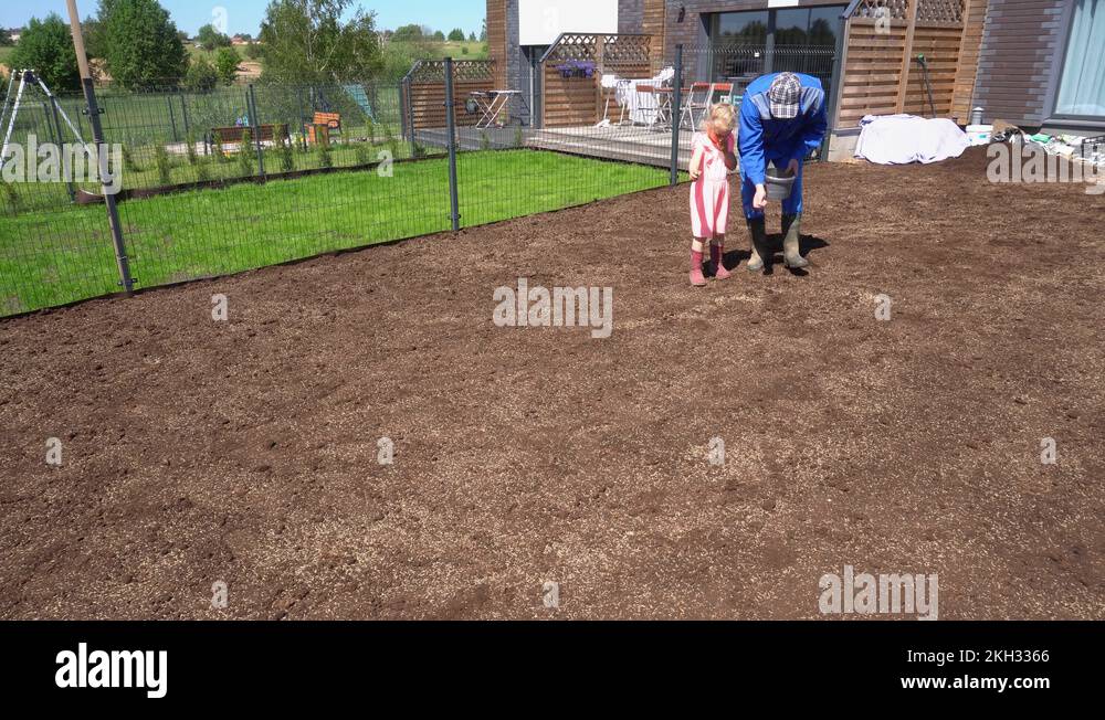 Cute girl daughter help father dad with lawn grass seeding sowing in ...