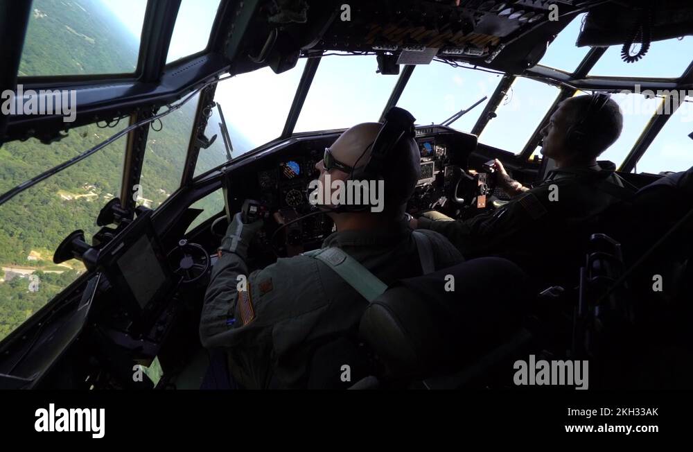 C-130 Hercules pilot looking out through cockpit window during flight ...