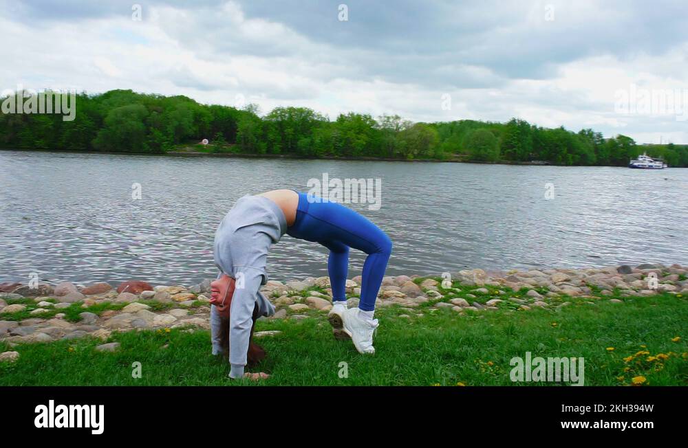 woman stretches standing in bridge position and raises leg Stock Video ...
