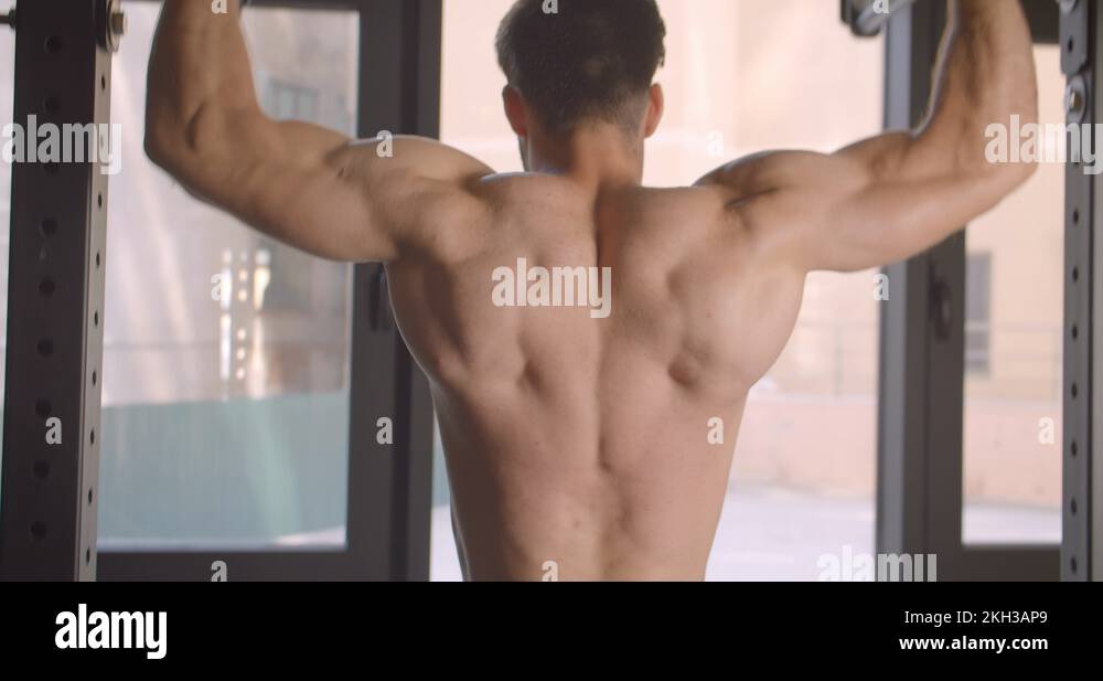 Closeup back view portrait of masculine shirtless muscular man pulling ...