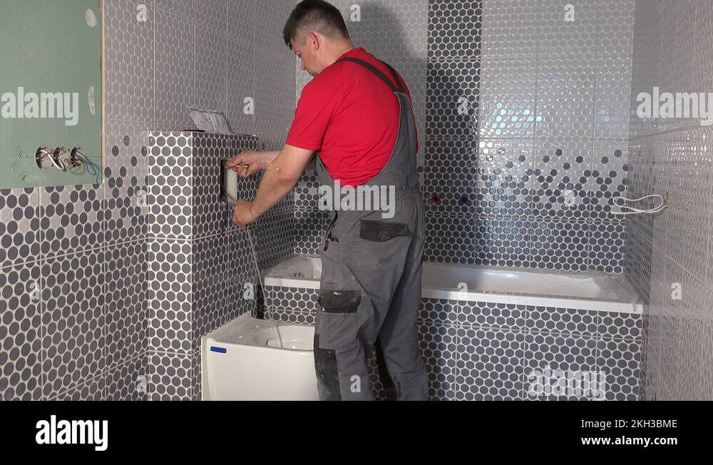 Plumber man flush water from tube of toilet flushing mechanism Stock ...