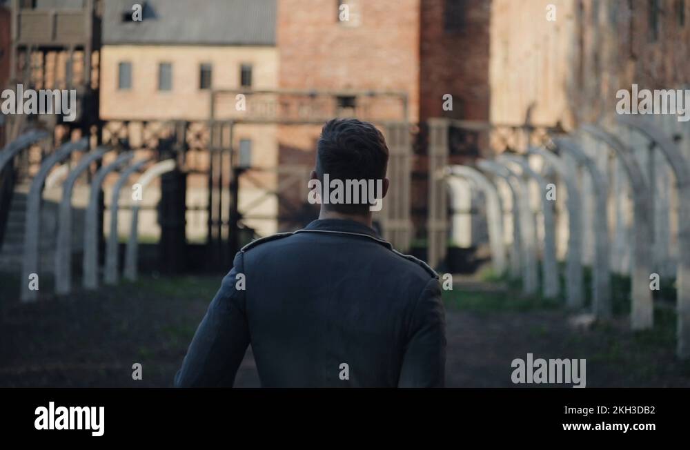 WWII reenactment. Back view of a young handsome German soldier with a ...