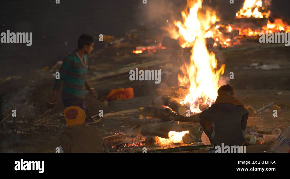 Young poor boy burning dead bodies in Manikarnika Ghat, Varanasi, India ...