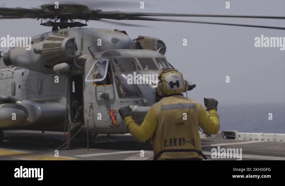 Aircraft handler signalling to pilot of CH-53 Super Stallion aboard USS ...