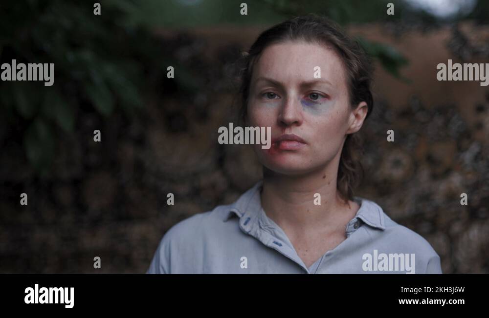 The face of a frightened battered woman outdoor. Combating domestic ...
