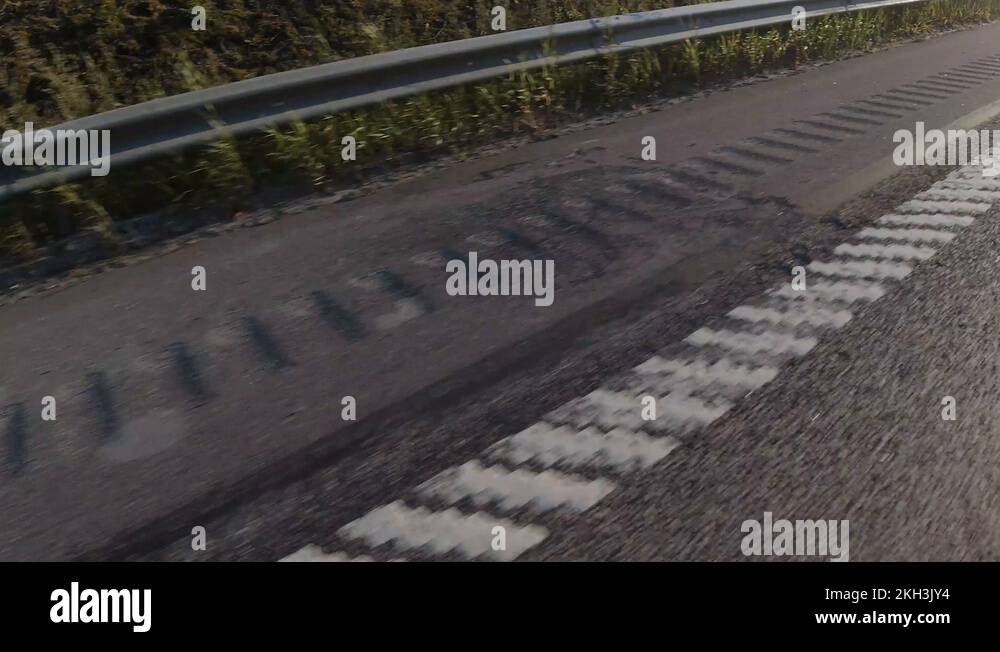 Dutch angle tilt rear view asphalt road close up low angle fast car in ...