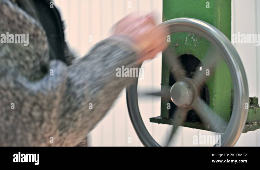 Close-up of hands A male researcher rotates the manual wheel of the ...