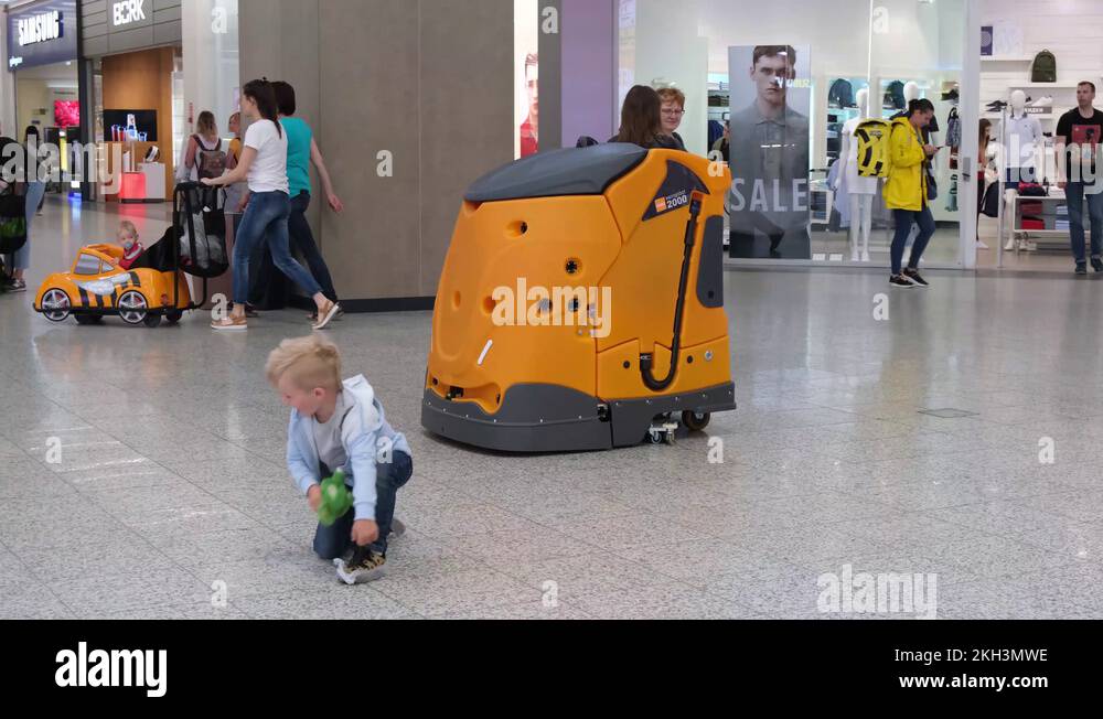 Big orange robotic vacuum cleaner in shopping mall. Taski swingobot ...