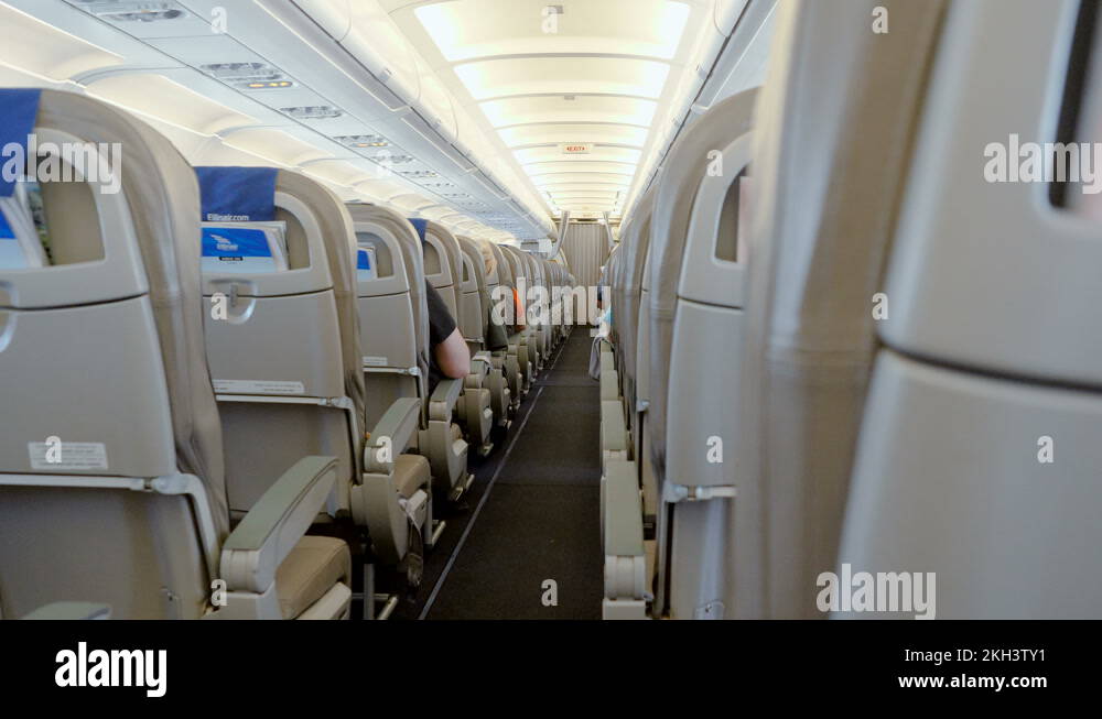 Interior of aircraft. Rows of seats on the plane with passengers on ...