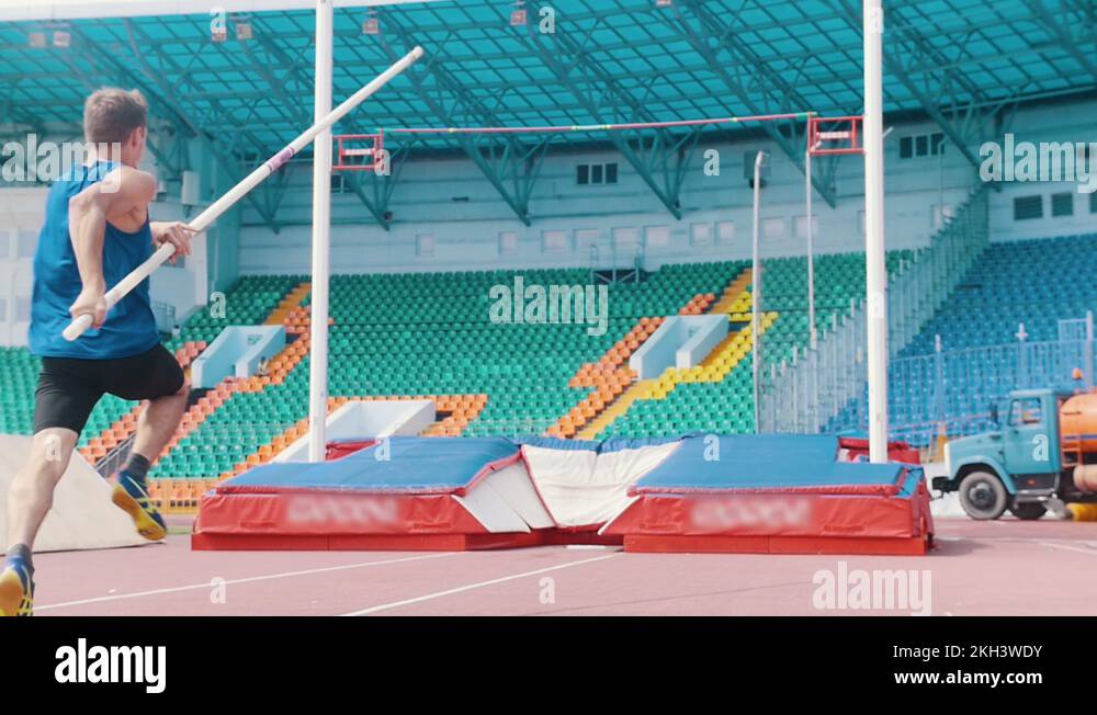 Pole vault training - an athletic man jumping over the bar in the ...