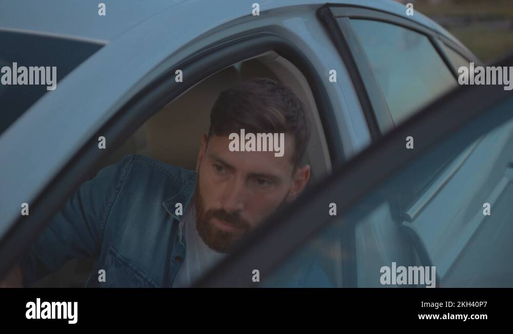 Young male driver gets out of car and looks on breakdown autonmobile on ...