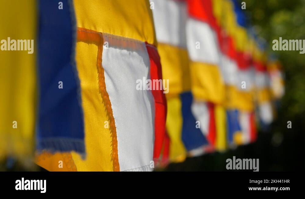 Buddhist prayer flags swaying in the wind in the rays of the rising sun ...
