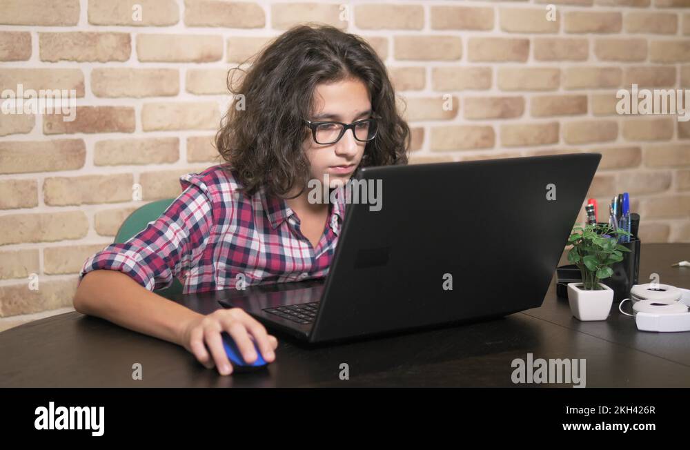 Working on a laptop computer, typing on a keyboard, modern teenager. A ...