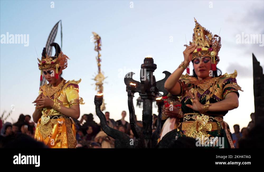 Two women with bright makeup and beautiful costumes dance Kecak dance ...