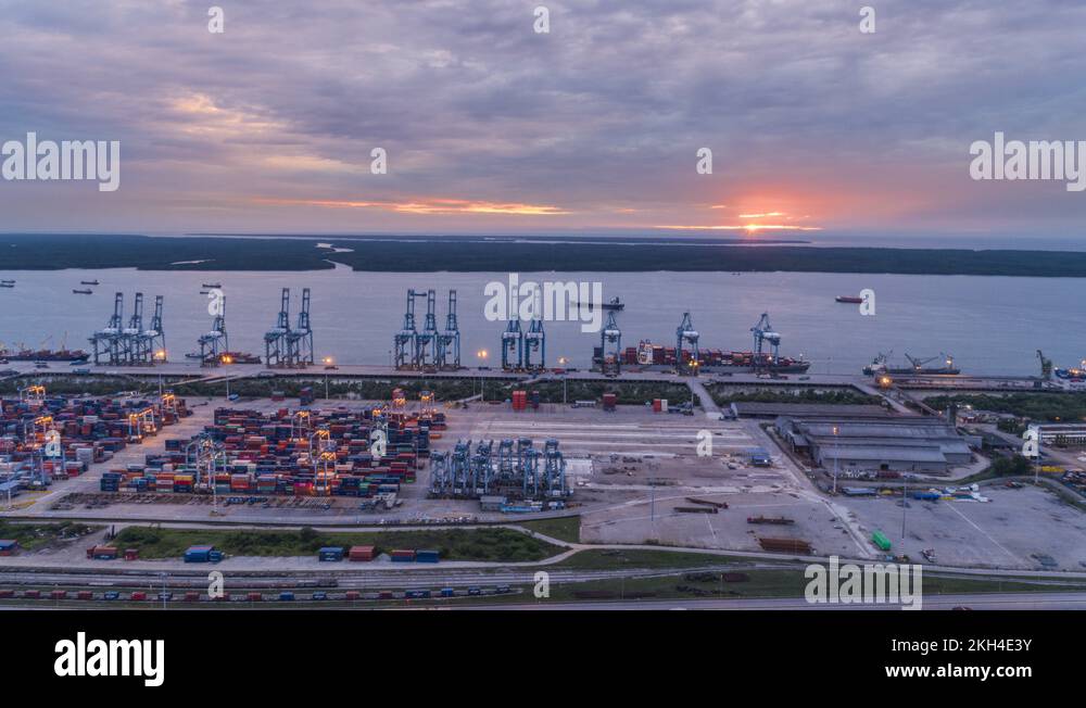Crane in the midst of lifting container into vessel in 4k time lapse ...