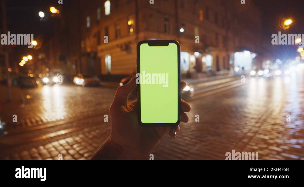 Sociable man showing vertical smartphone green screen chomekey in first ...