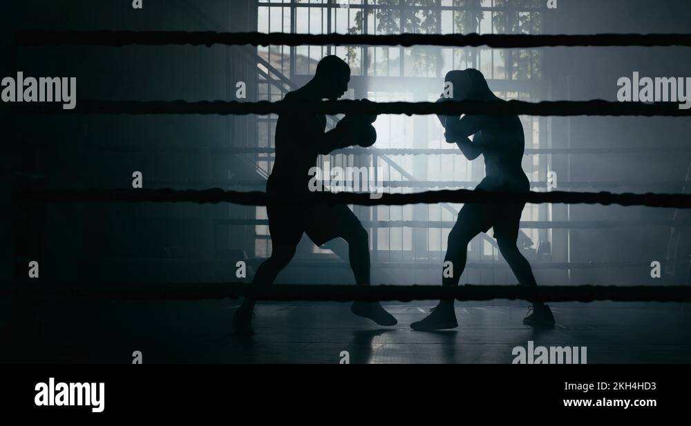 Cinematic shot of two young male boxers are fighting in a boxing ring ...