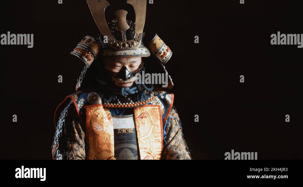 Man in traditional japanese samurai clothing is looking at camera and ...