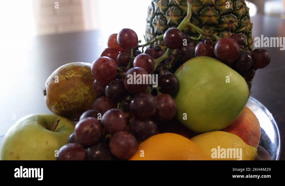 Pineapple, apple, red grapes, lemon, orange. the camera moves around ...