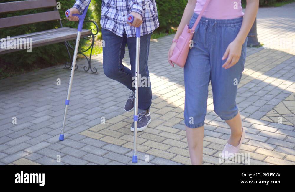 Young asian man with broken leg on crutches communicates with young ...