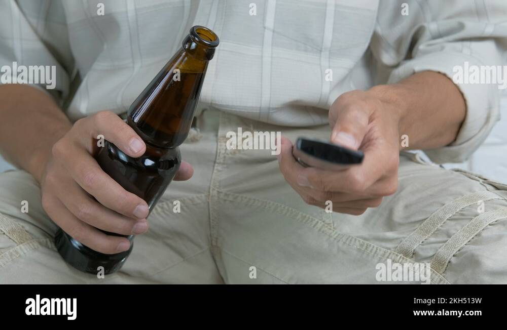A man with a TV remote control is drinking beer Stock Video Footage - Alamy