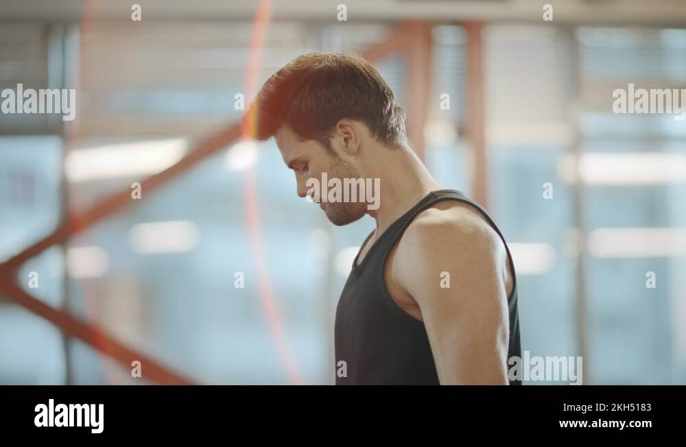 Strong guy lifting dumbbells in sport club. Tired sport man training ...