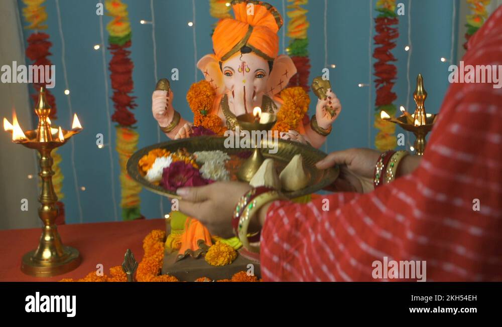 Overhead shot of an Indian female worshipping Lord Ganesha with Puja ...