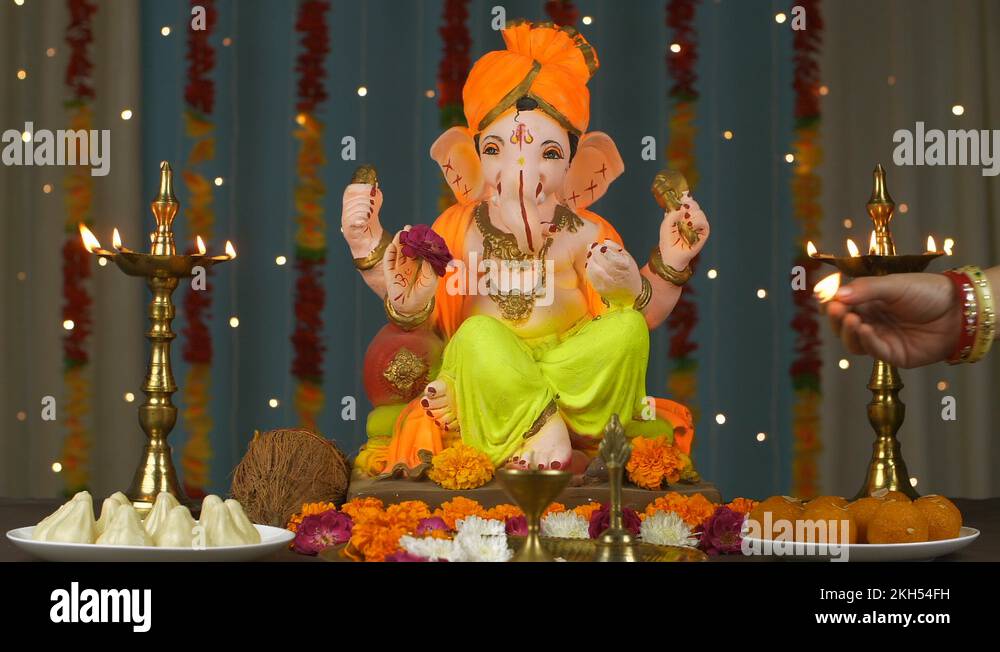 Shot of an Indian female's hand lighting up a diya / lamp for puja of ...