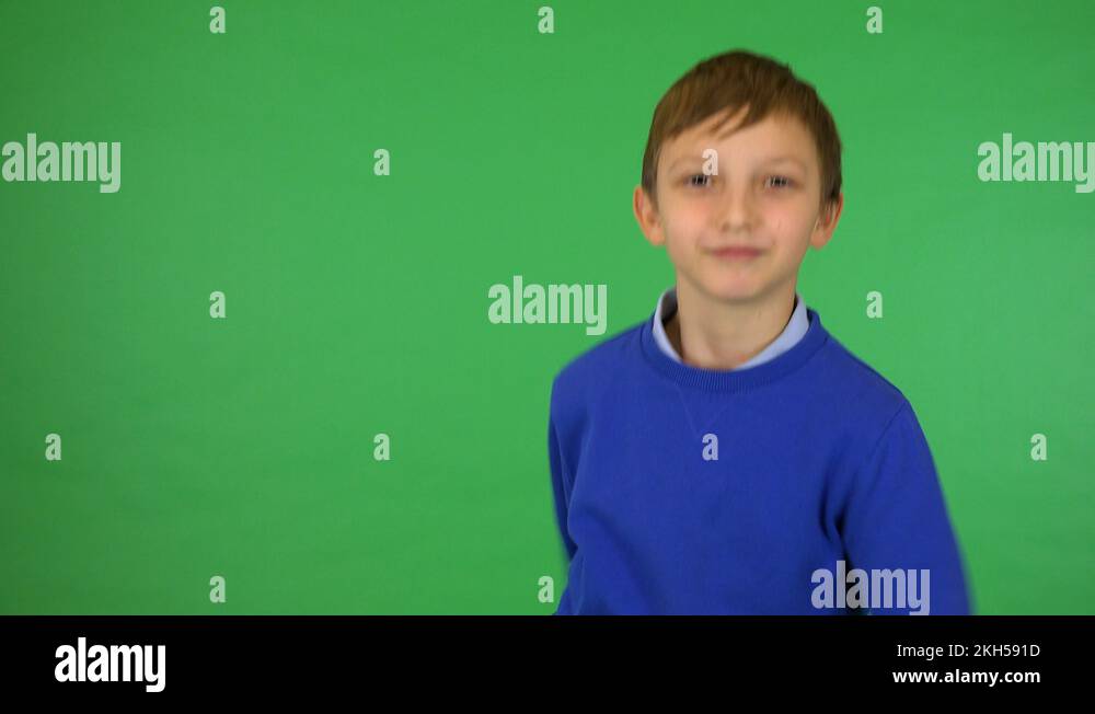 A young cute boy does the floss dance and smiles at the camera - green ...