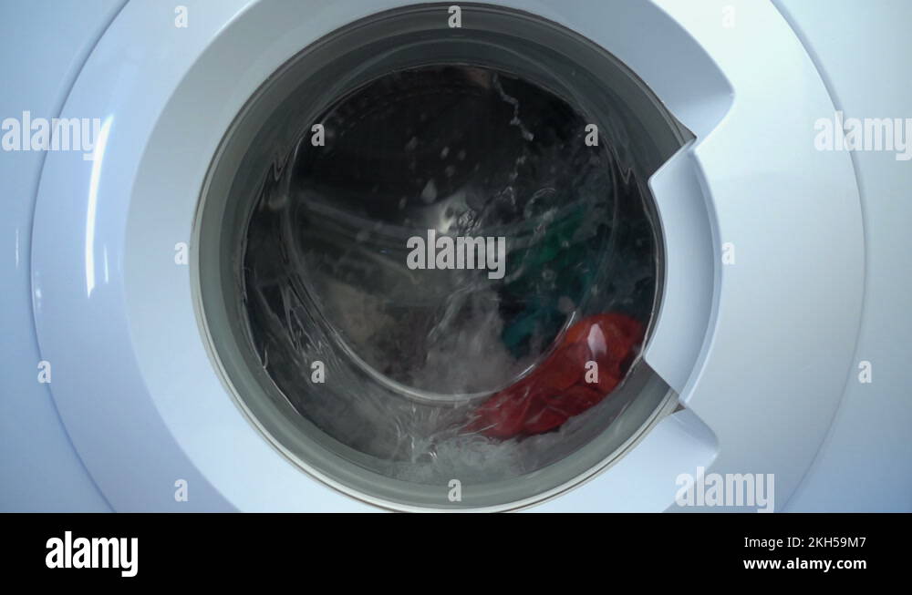 Close up view porthole of washing machine. Washing clothes process in ...