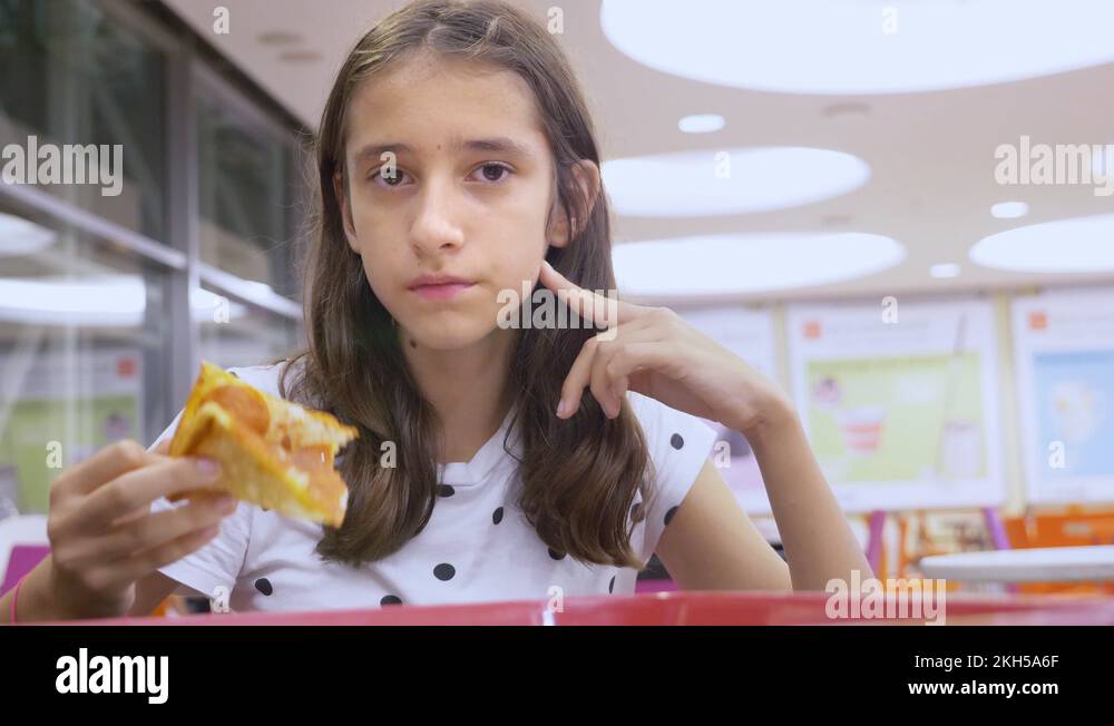 Close-up. face teen girl eating pizza in a fast food restaurant Stock ...