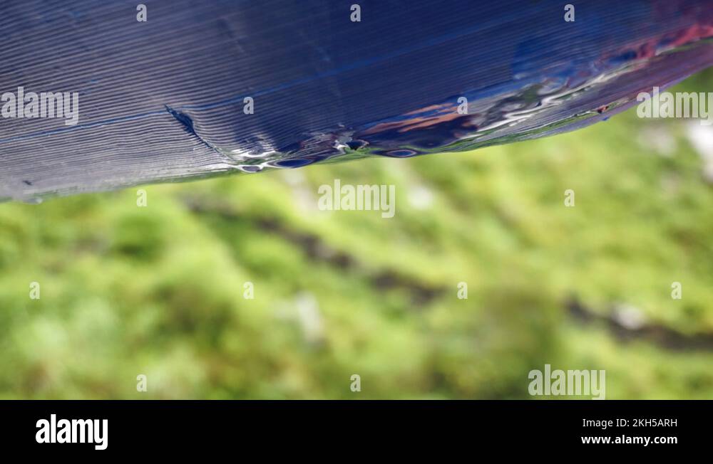 Rain drops falling from the blue tarpaulin plastic that hikers and ...