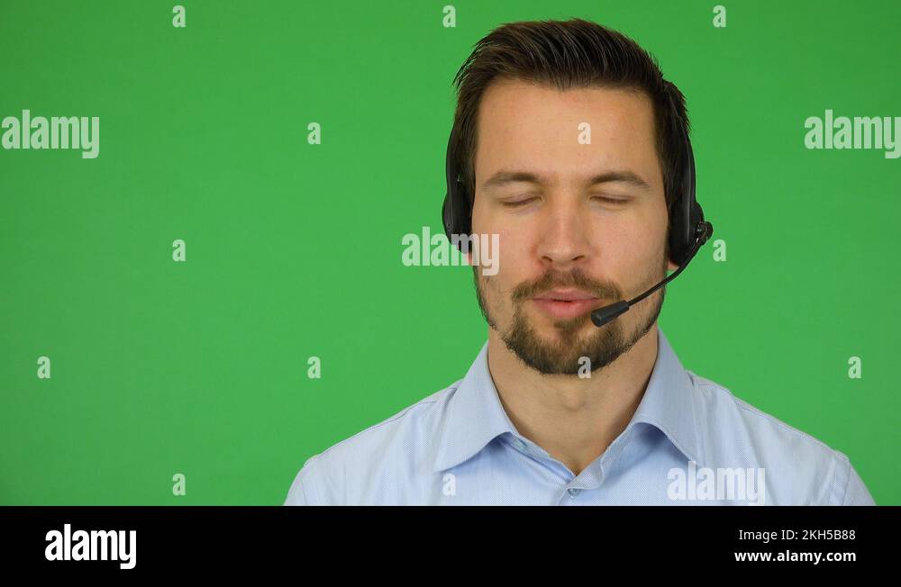 A young handsome call center agent talks to the camera with a smile ...