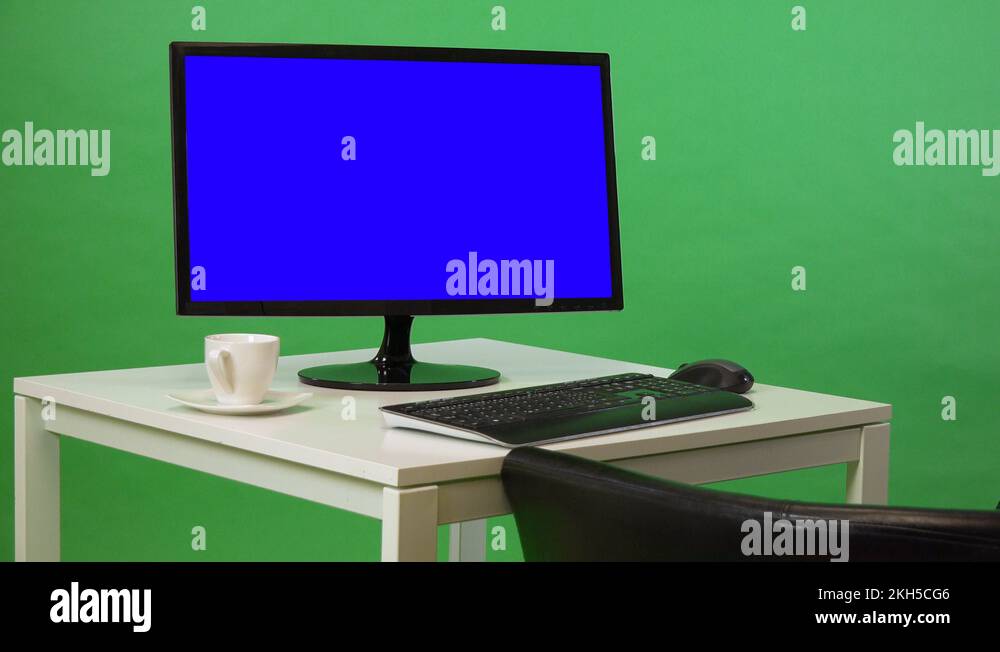 Desktop computer with blue screen on a working desk - green screen ...