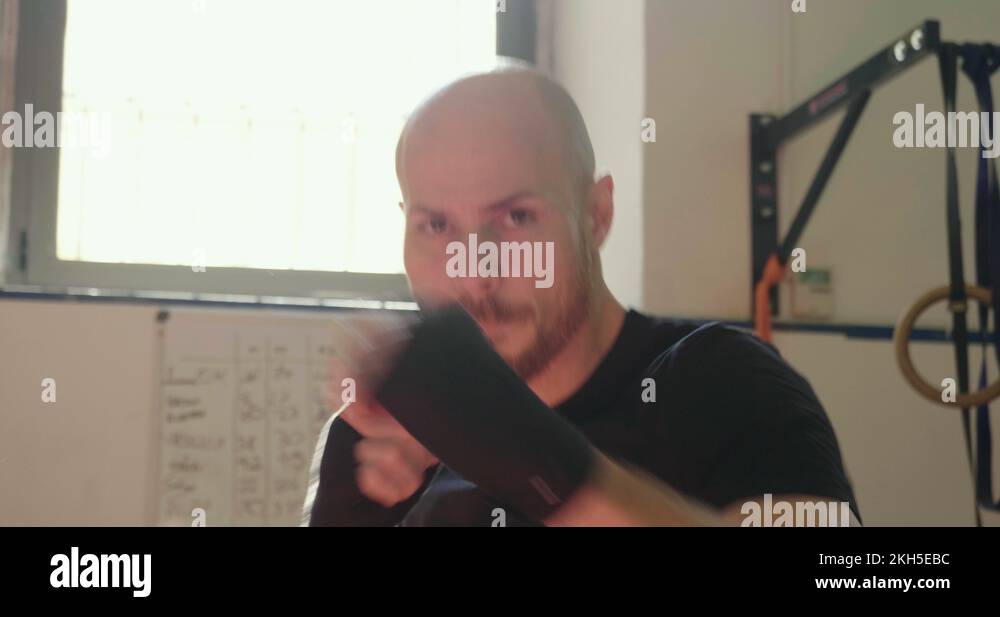 A professional young kickboxer with fit body is making a routine ...