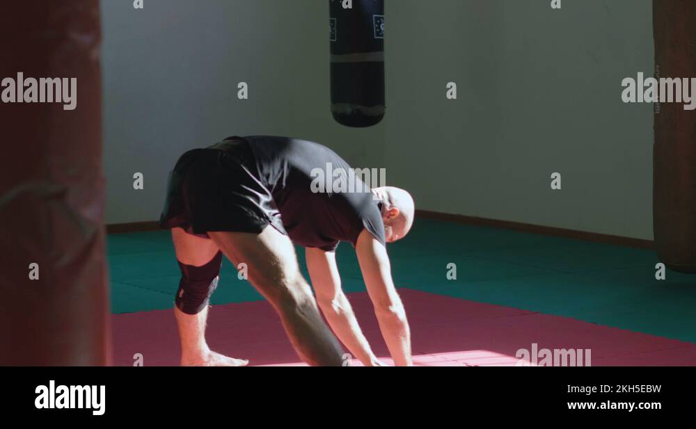 A professional young kickboxer with fit body is making a routine ...