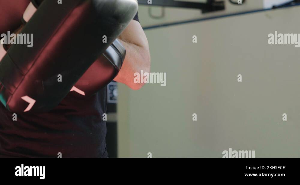 A professional young kickboxer with fit body is making a routine ...