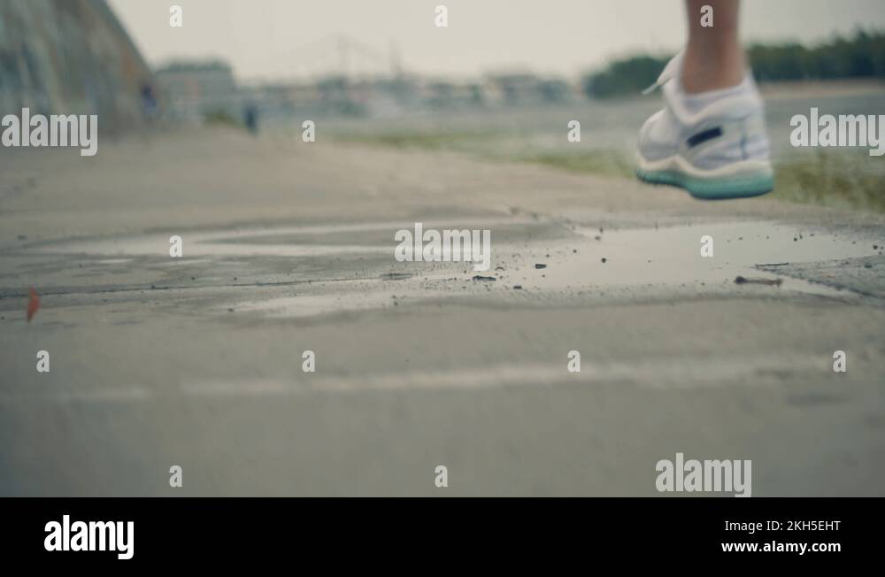 Running Man On Puddle.Puddle Splash Man Jogging.Close Up Legs Running ...