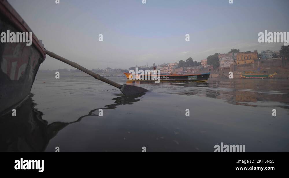 Indian men rowing boat at sunrise in the Holy river Ganges, Varanasi ...