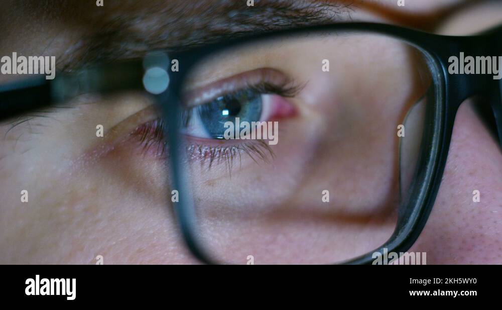 Macro of eyes with glasses of a web surfer or a workaholic while ...